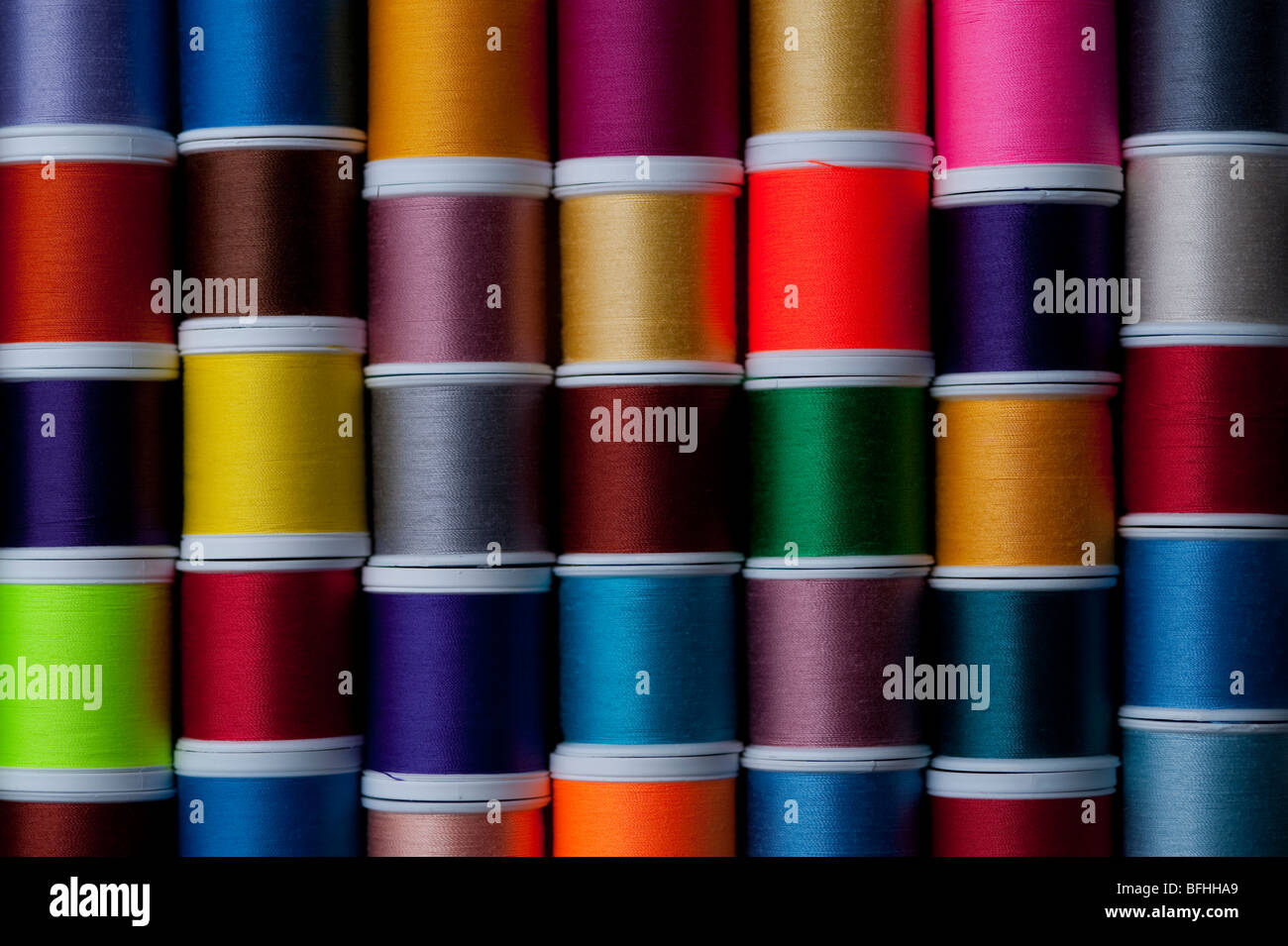 Bright colored spools of thread in rows Stock Photo - Alamy