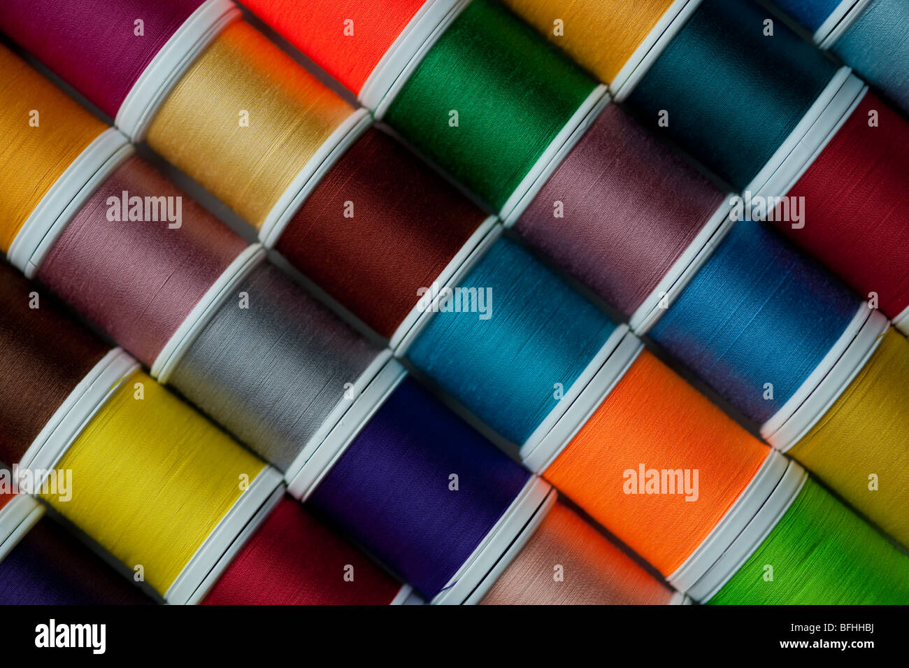 Bright colored spools of thread in rows Stock Photo - Alamy
