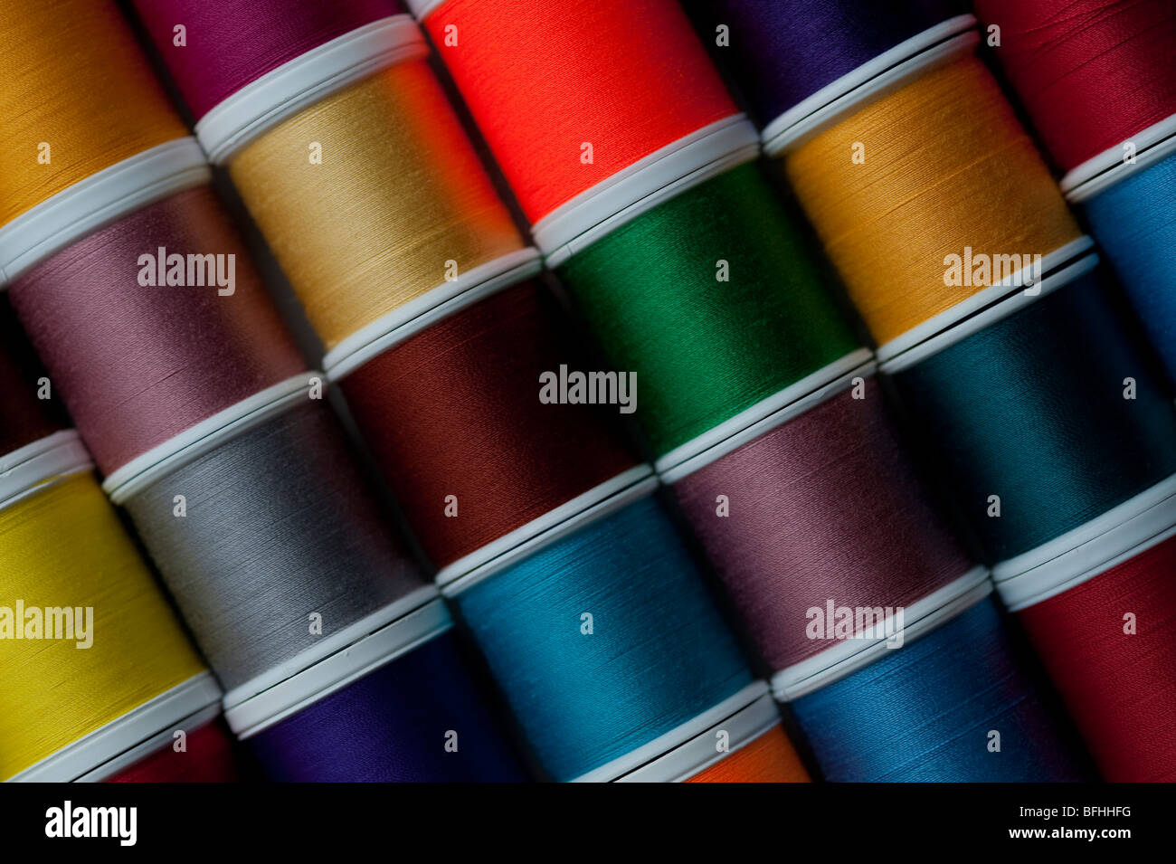 Bright colored spools of thread in rows Stock Photo - Alamy