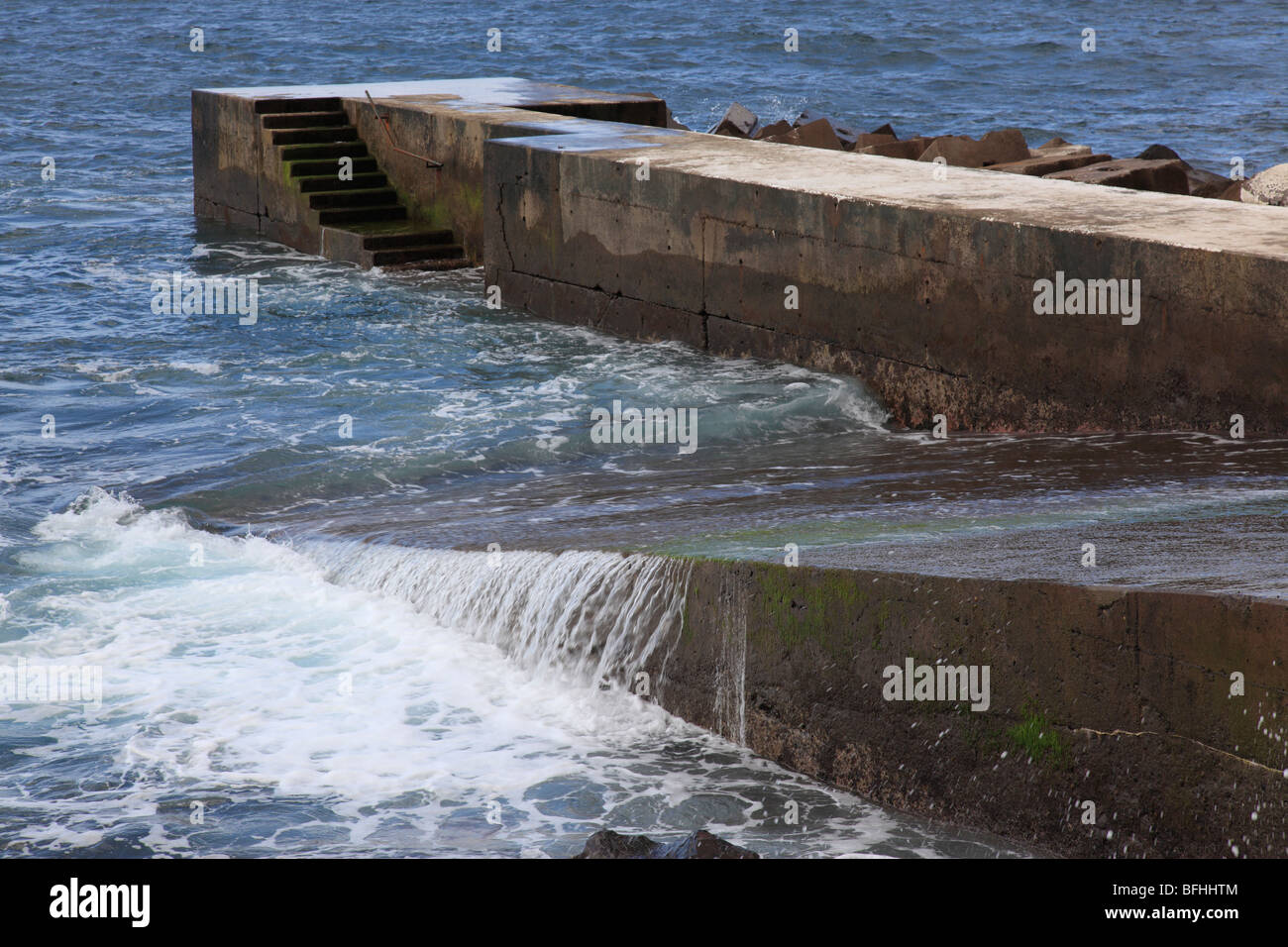 Atlantic Ocean wave hitting concrete sea wall on the beach of the ...