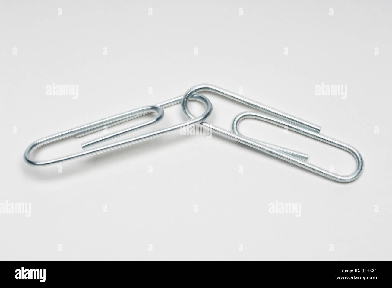 Two silver paper clips on white background Stock Photo - Alamy