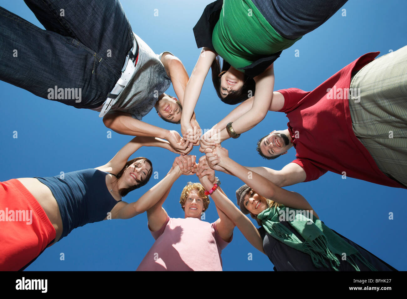 Group of young people in circle, view from below Stock Photo - Alamy