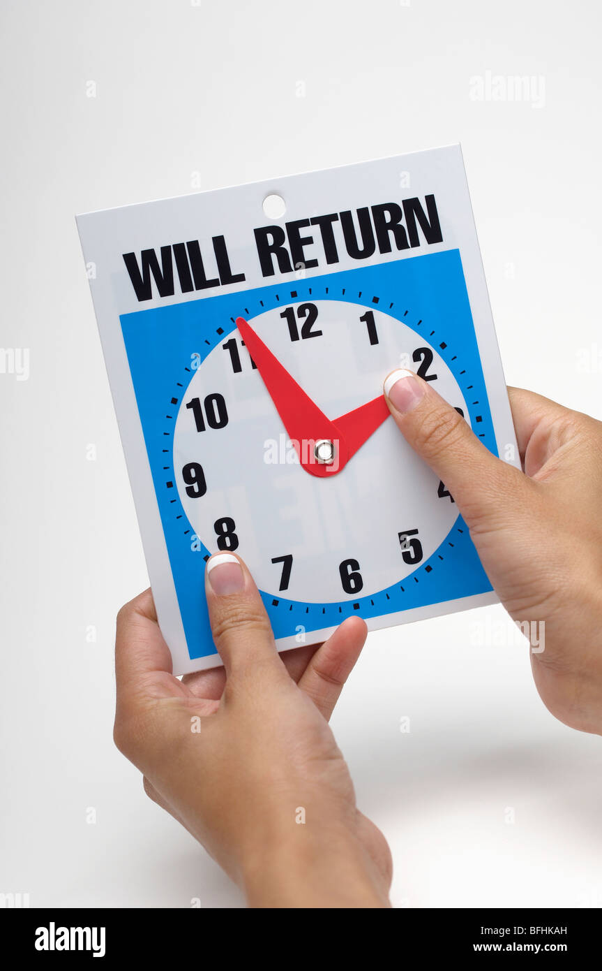 Woman adjusting hands of Will return clock, close-up Stock Photo - Alamy