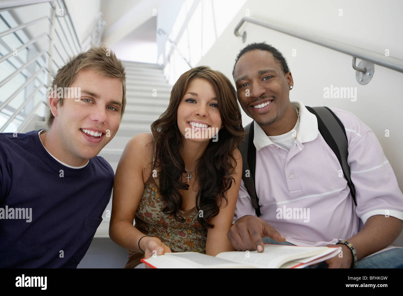 Three students working on stairs in school, portrait Stock Photo - Alamy