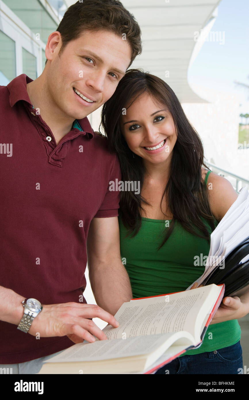 Two students holding books at school, smiling, portrait Stock Photo - Alamy