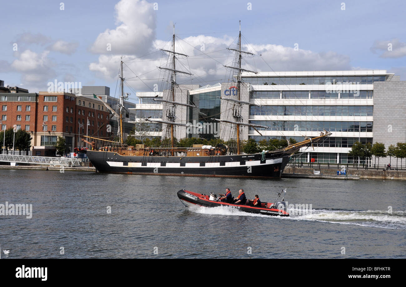 Firemen pass the Janie Johnson Sail Ship moored in the Liffey river ...