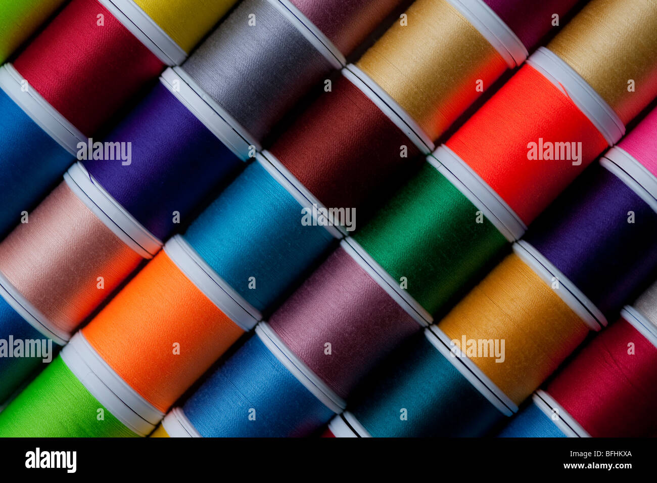 Bright colored spools of thread in rows Stock Photo - Alamy