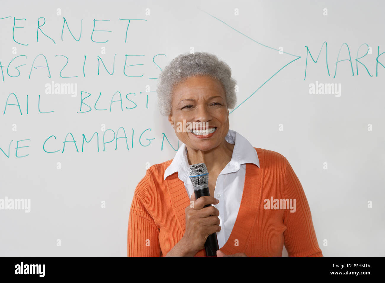 Female teacher using microphone near white board Stock Photo - Alamy