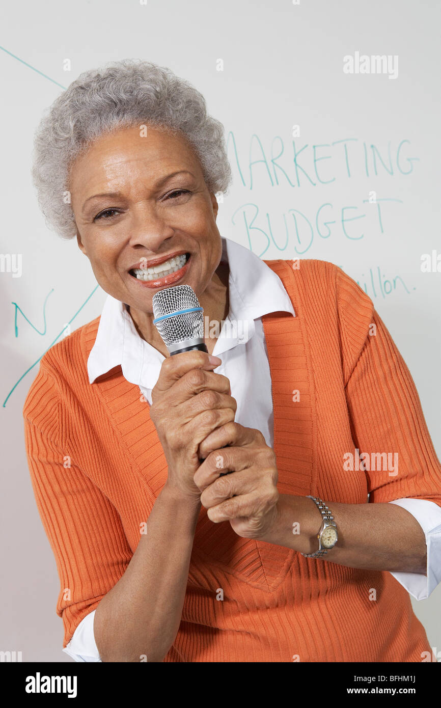 Female teacher using microphone near white board Stock Photo - Alamy