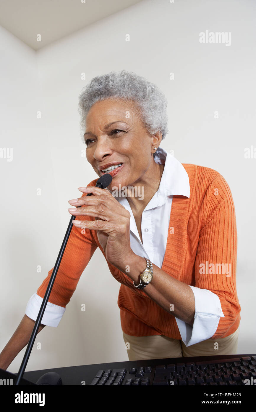 Female teacher using microphone indoors Stock Photo - Alamy