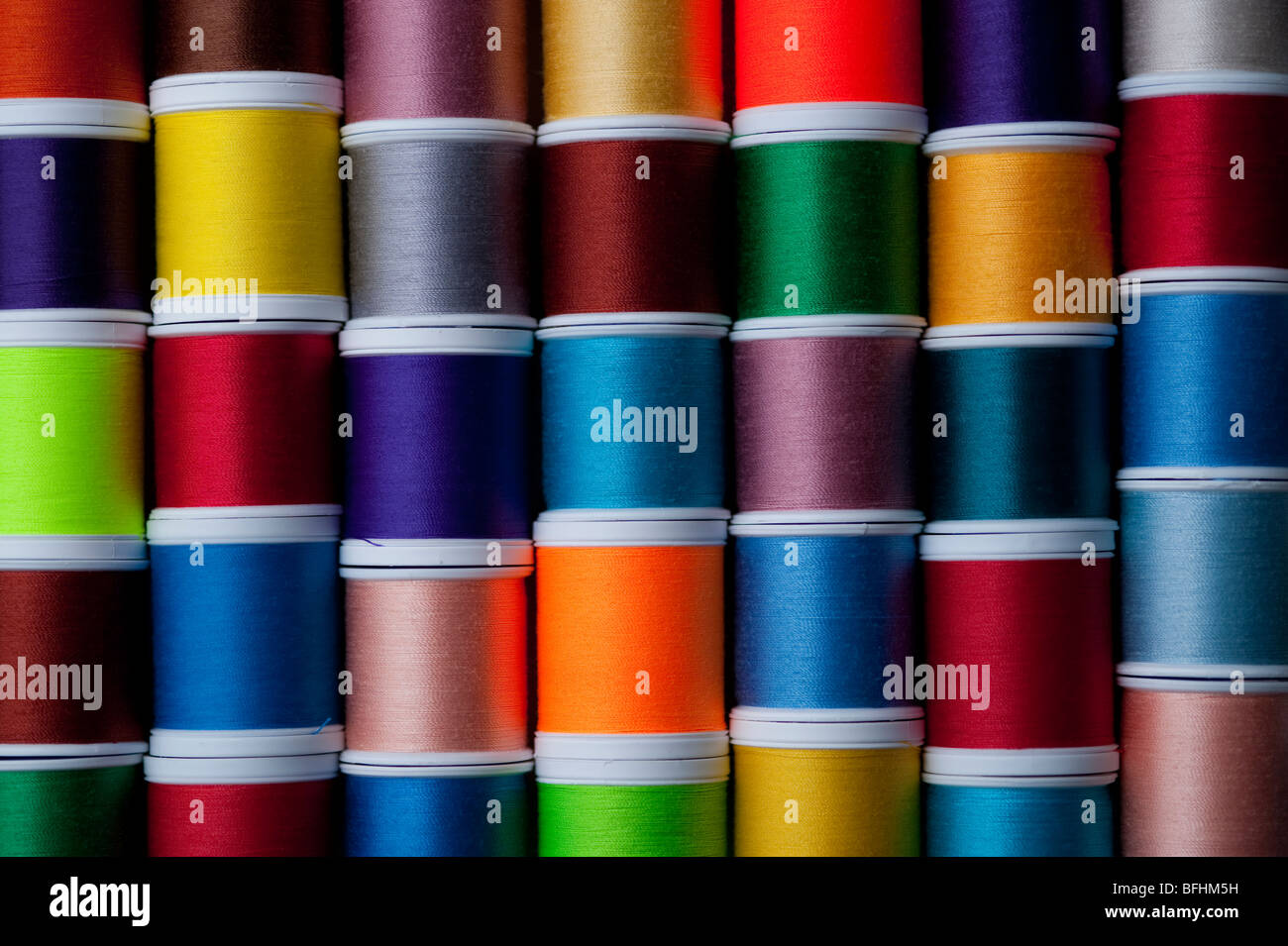 Bright colored spools of thread in rows Stock Photo - Alamy