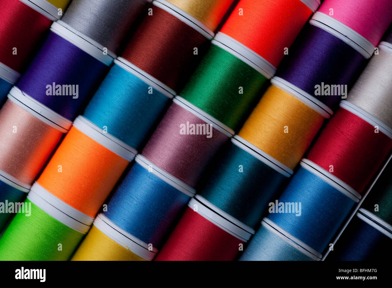 Bright colored spools of thread in rows Stock Photo - Alamy