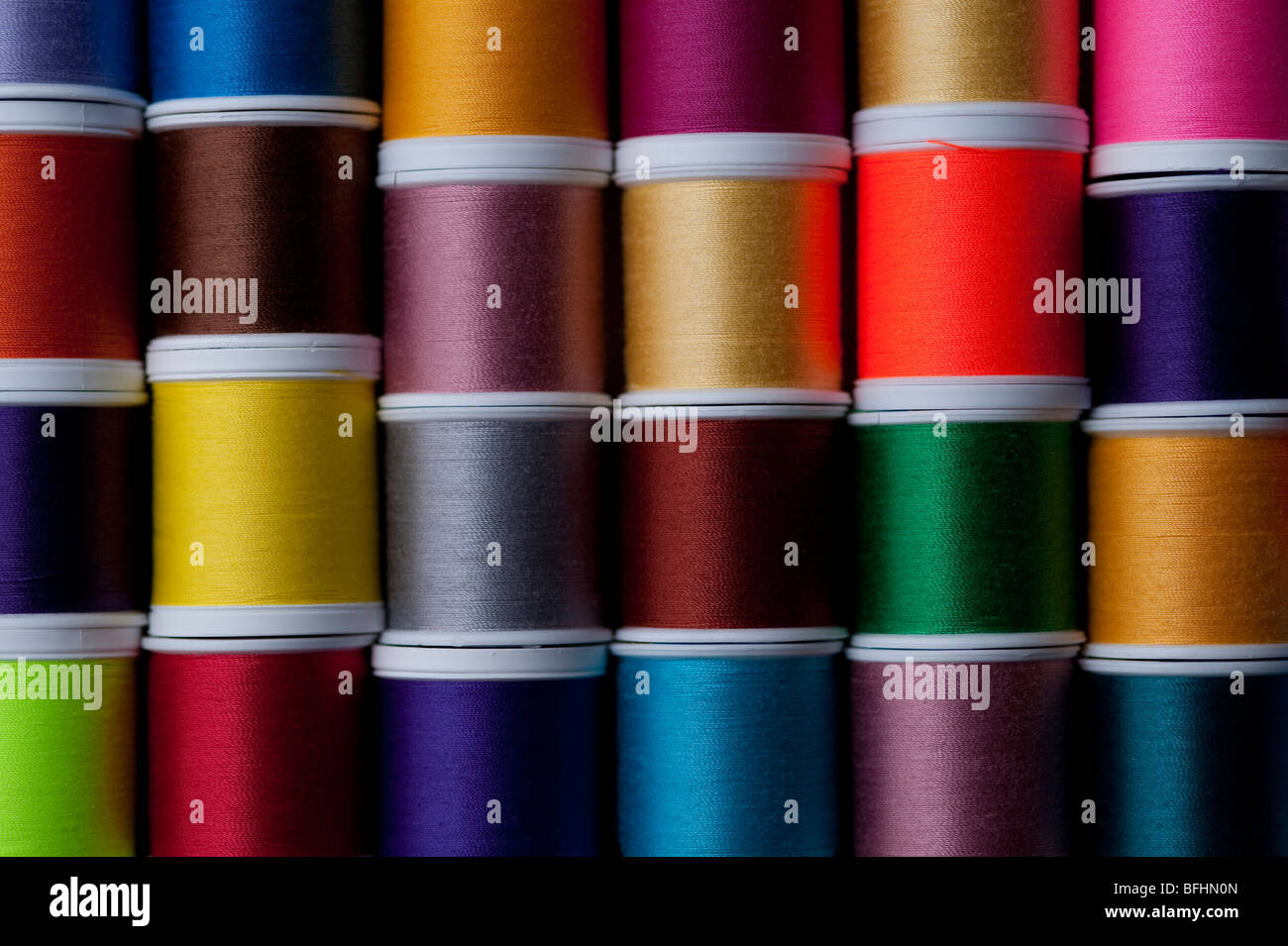 Bright colored spools of thread in rows Stock Photo - Alamy