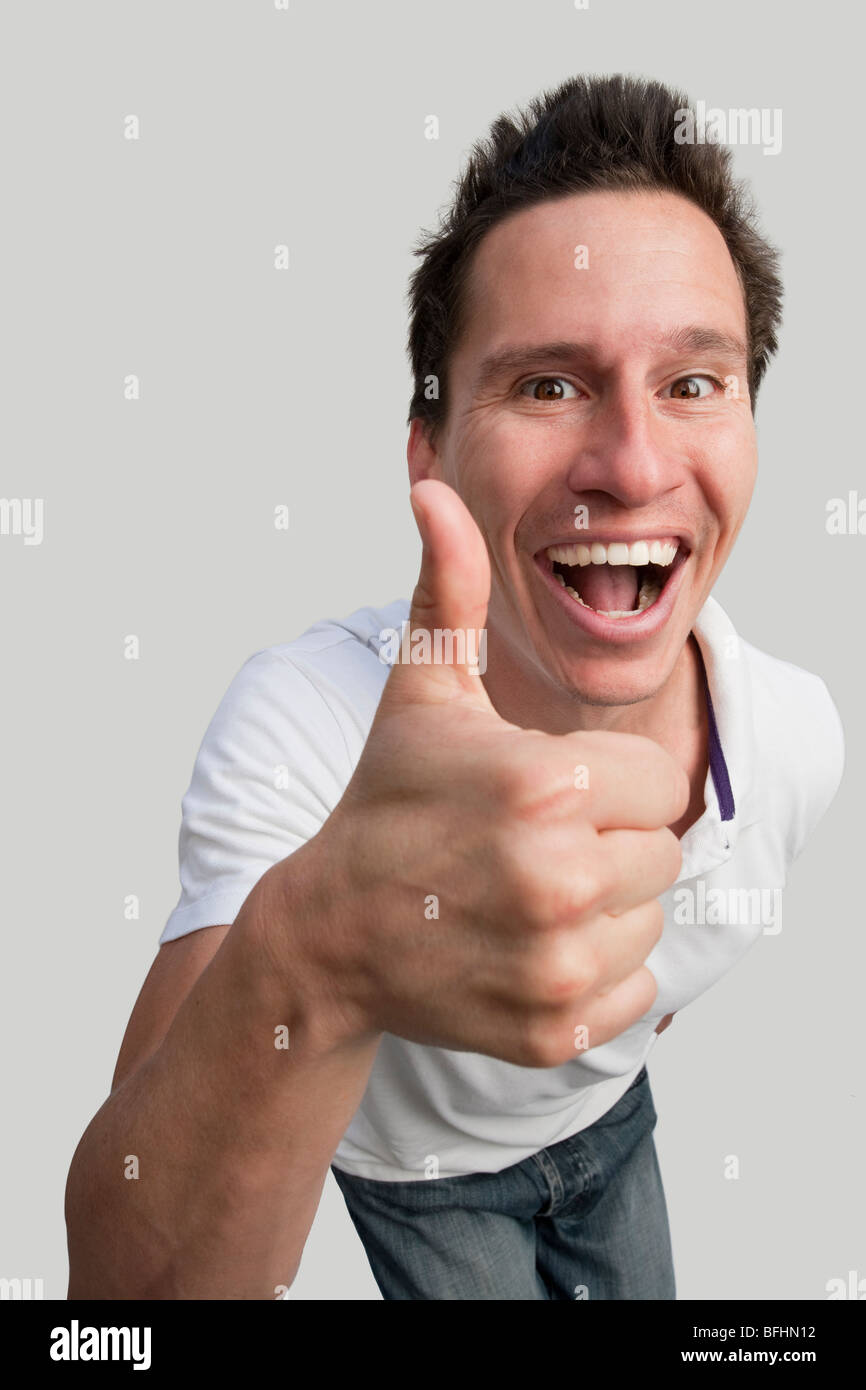 funny portrait of a young man giving thumb up Stock Photo - Alamy
