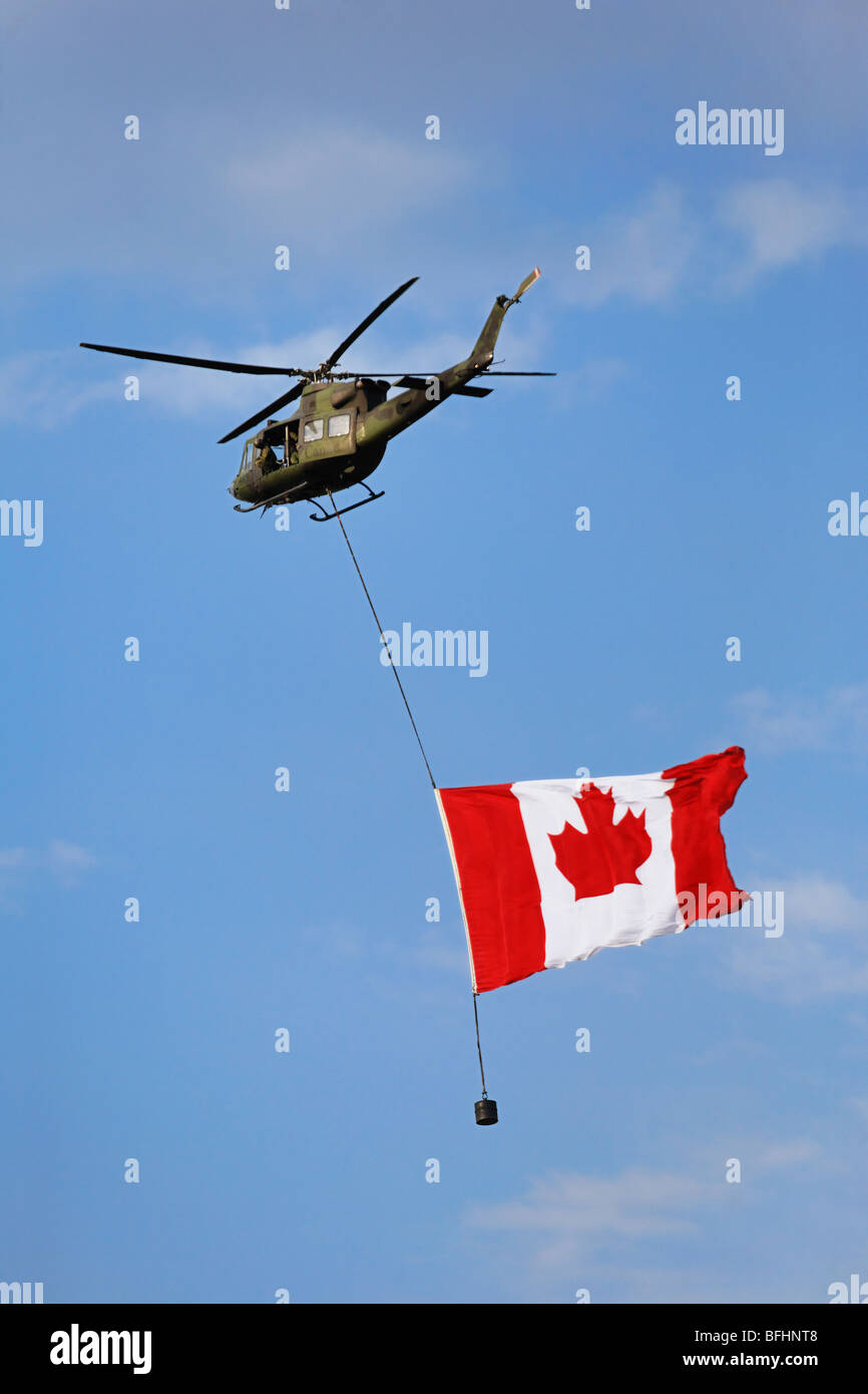 Canadian military helicopter displaying the national flag over the city ...