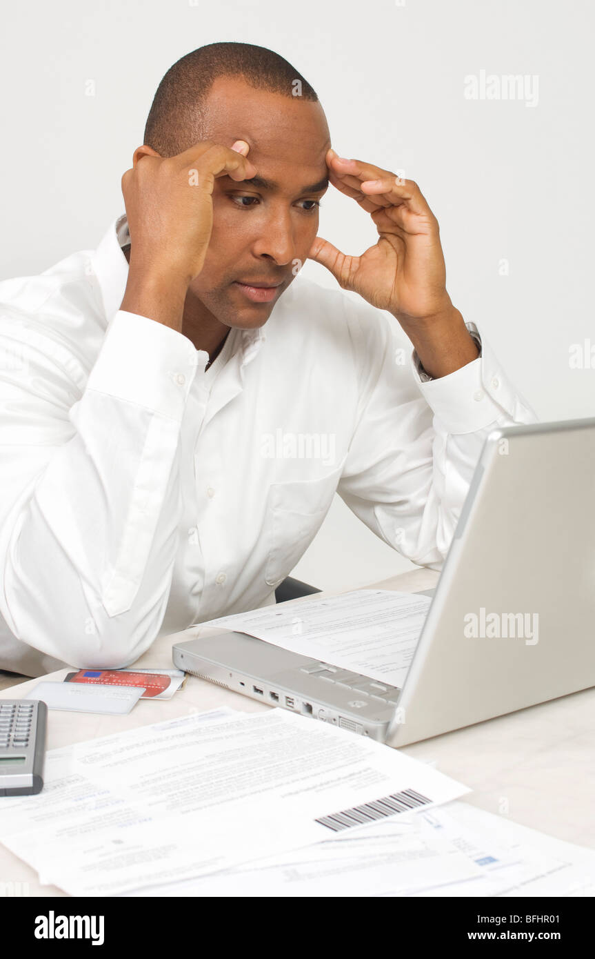 Man with a Laptop Figuring out Bills Stock Photo - Alamy