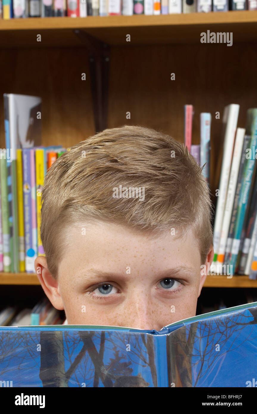 Boy peeking above book, close-up view Stock Photo - Alamy