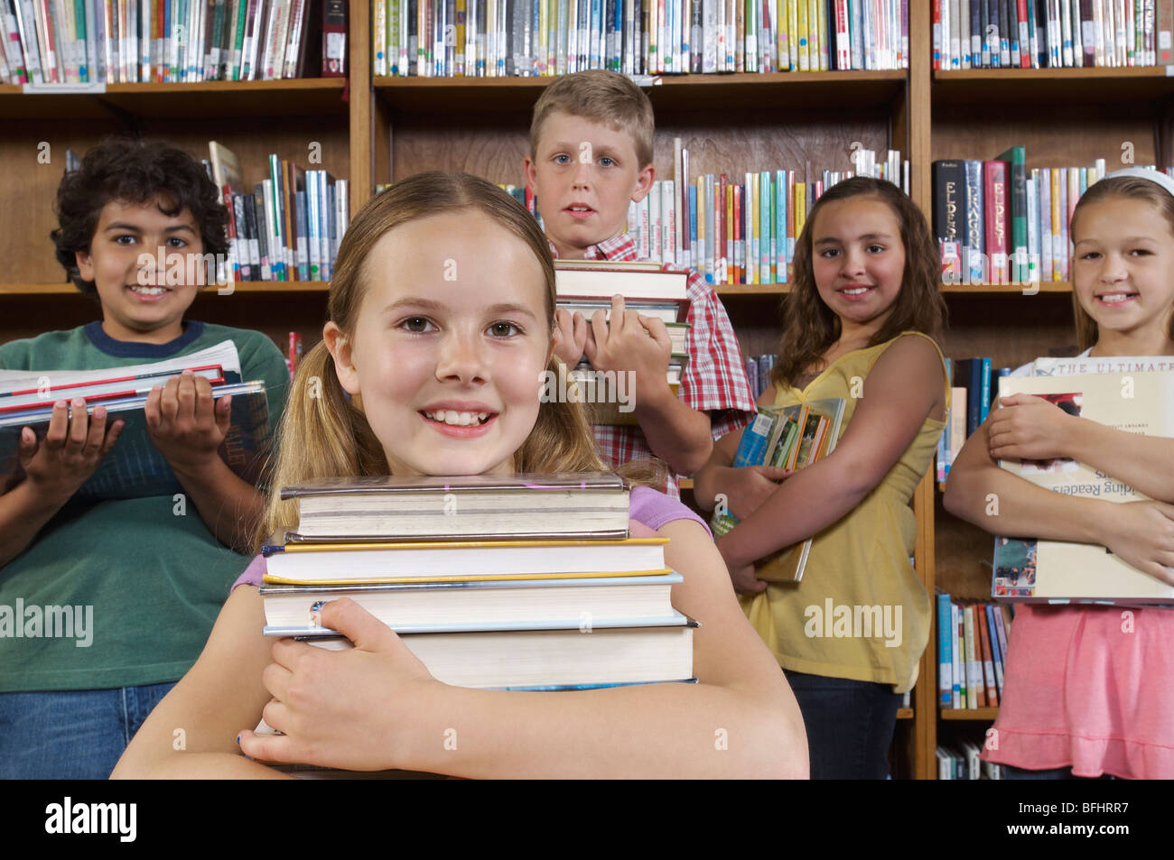School children holding books in library, portrait Stock Photo - Alamy