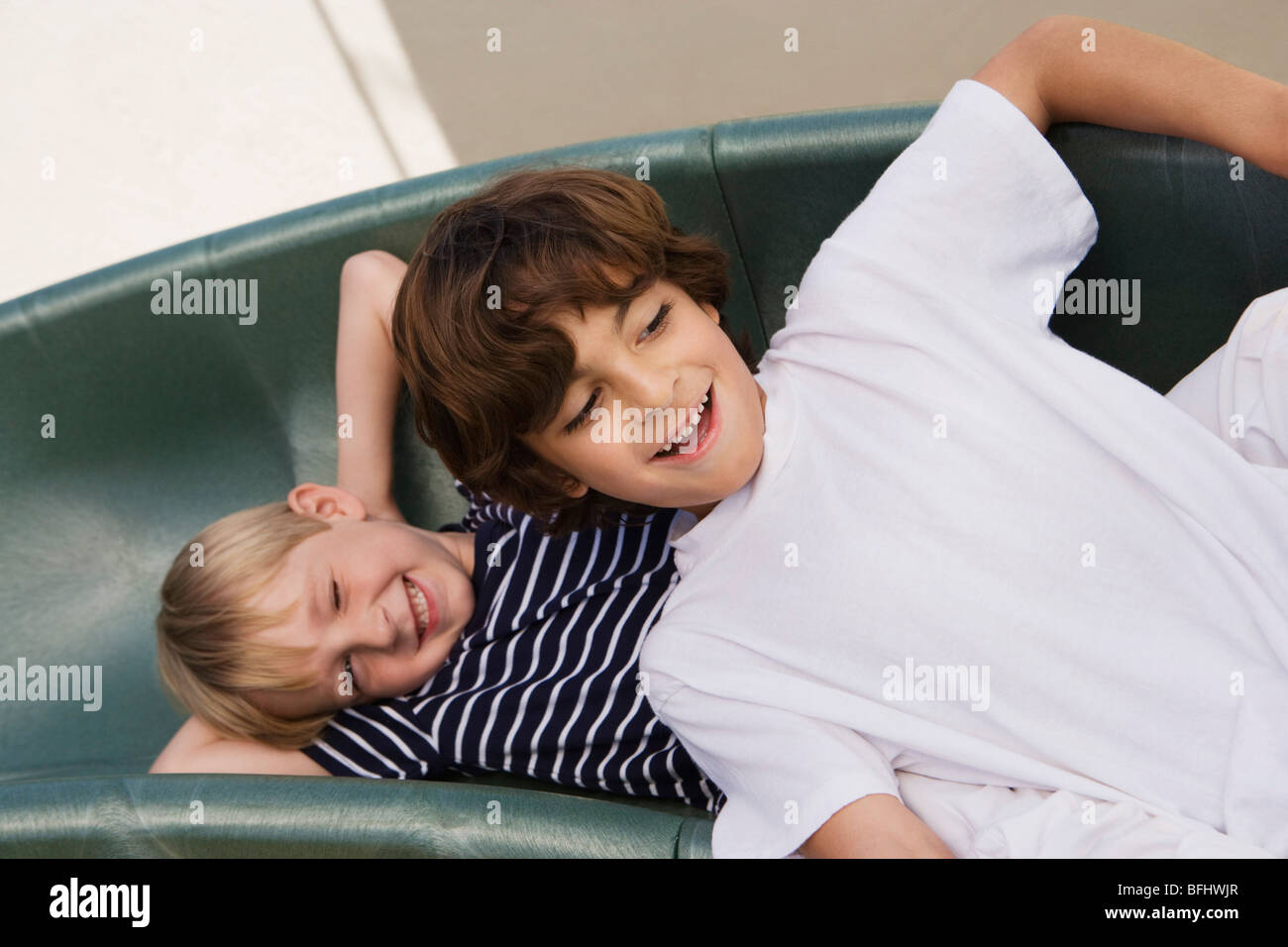 Two children sliding down a slide hi-res stock photography and images ...