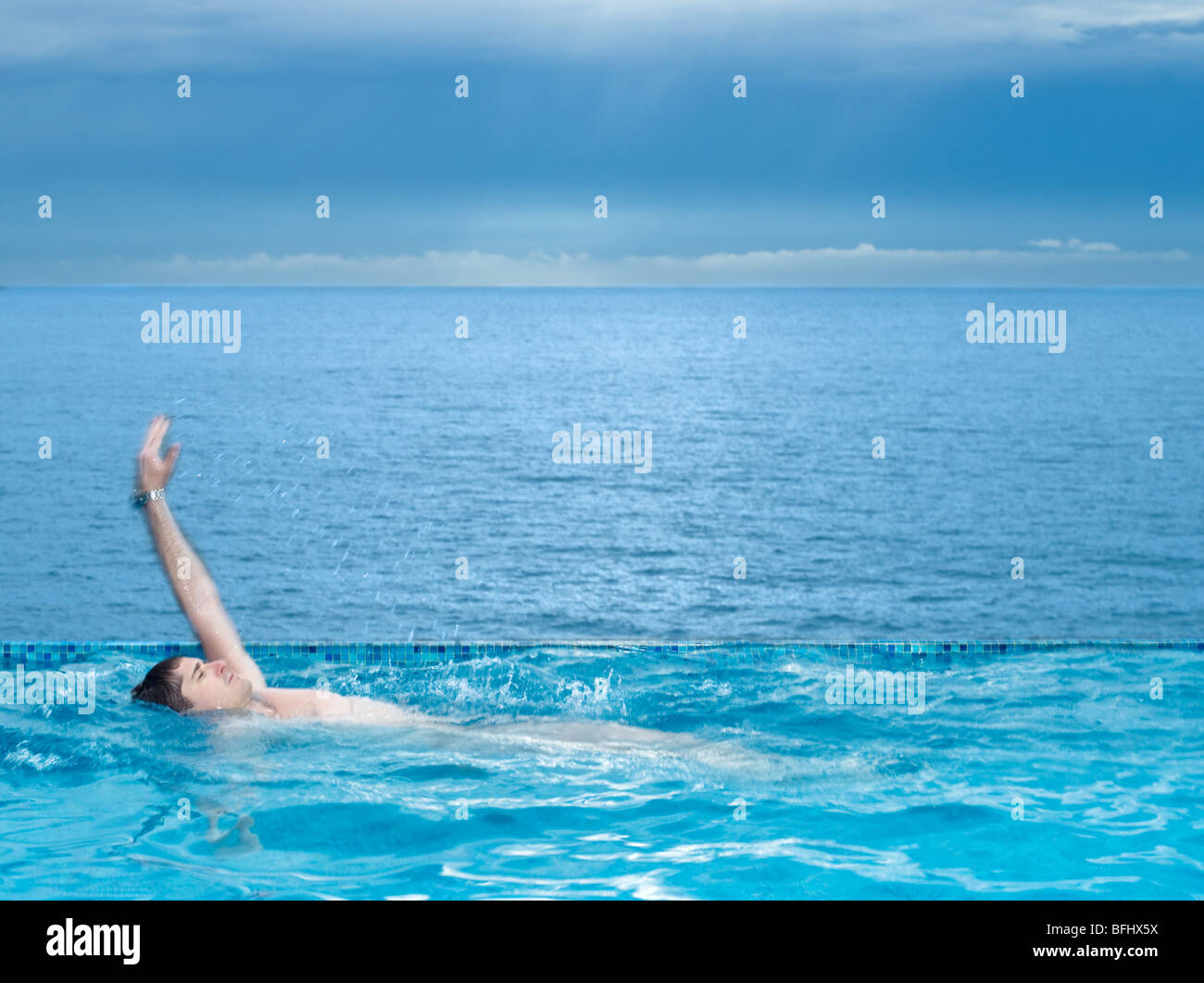 man swimming in a beautiful swimming pool by the seaside Stock Photo ...