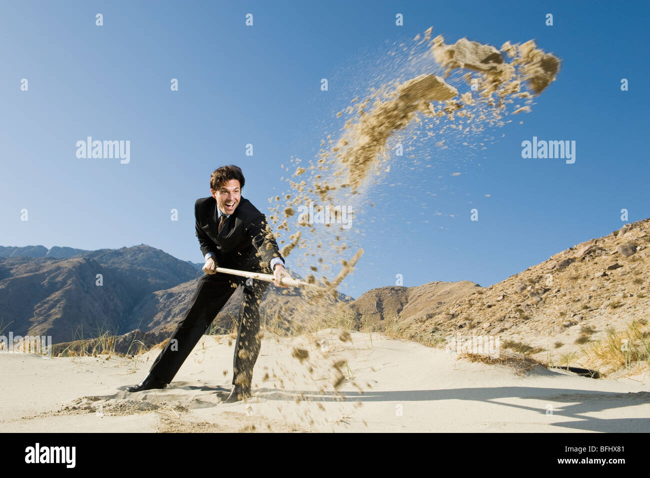 Businessman Digging With Spade in the Desert Stock Photo - Alamy