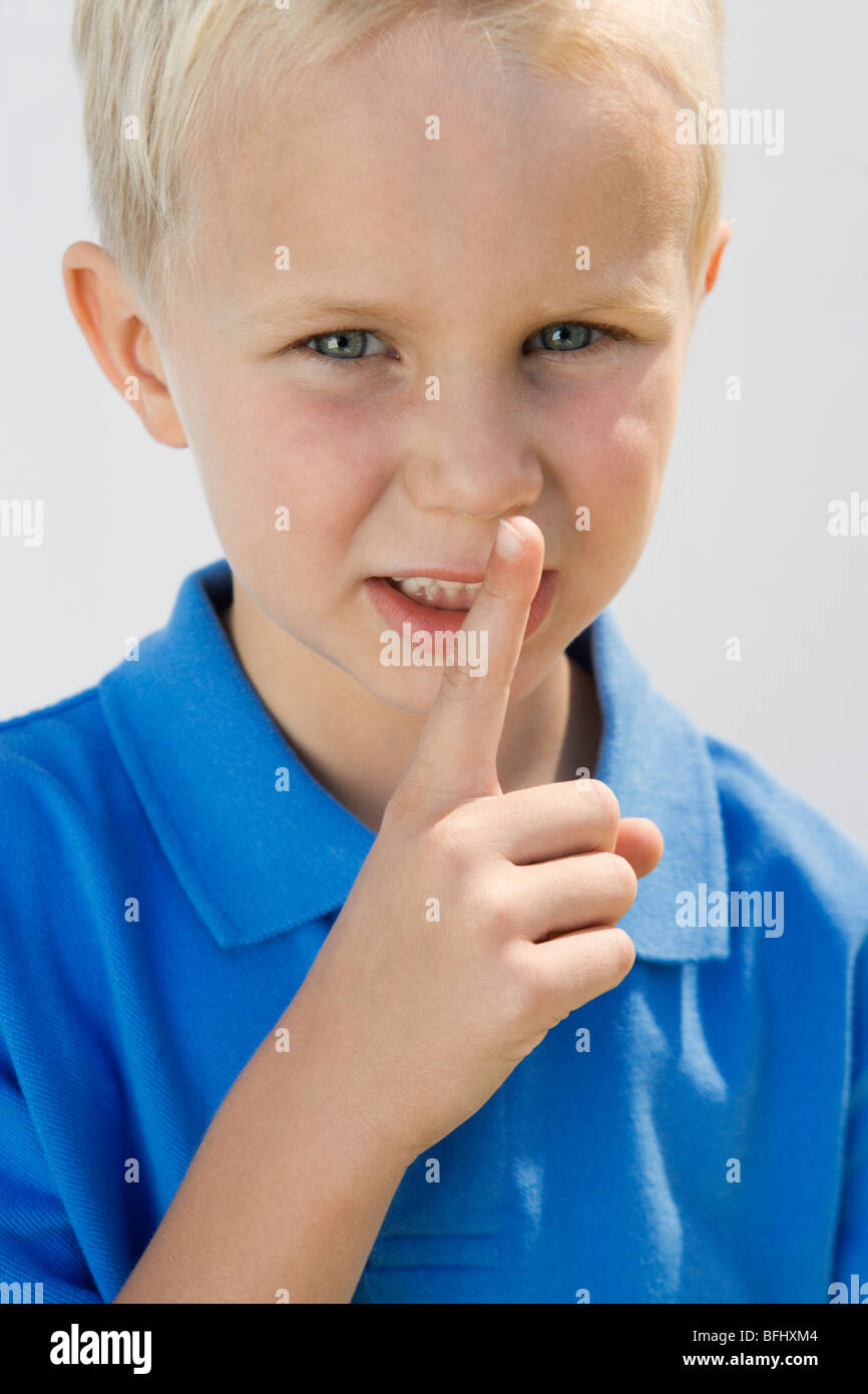 Boy with Finger on Lips Stock Photo - Alamy