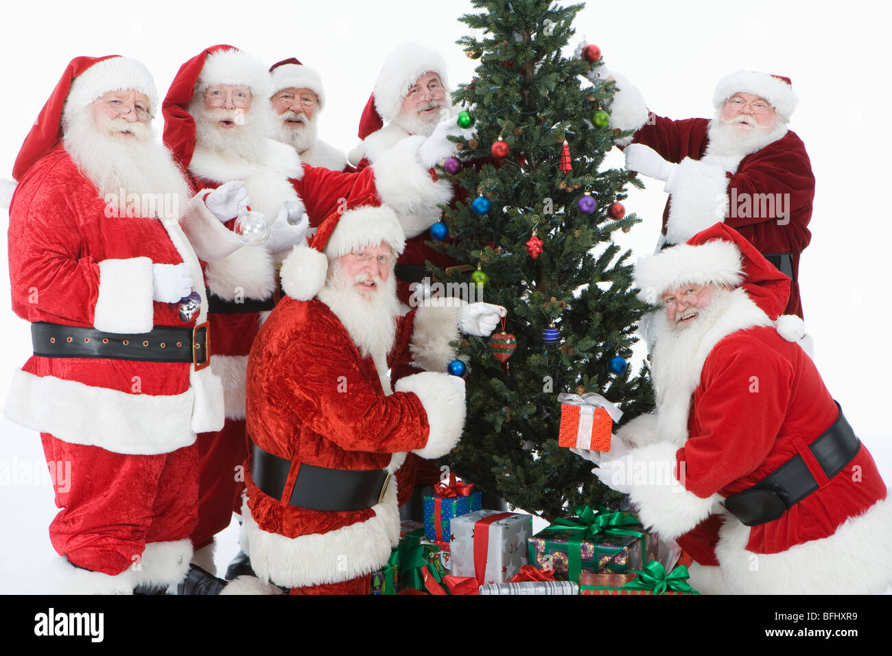 Group of men dressed as Santa Claus decorating Christmas tree Stock ...