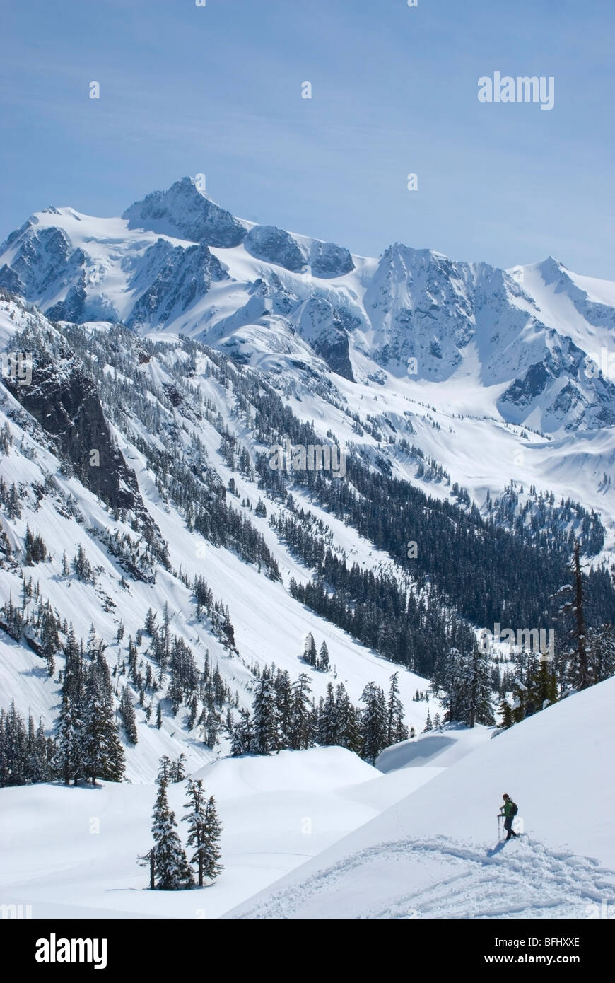 A lone snowshoer on a sunny spring day at Mount Baker with Mount ...