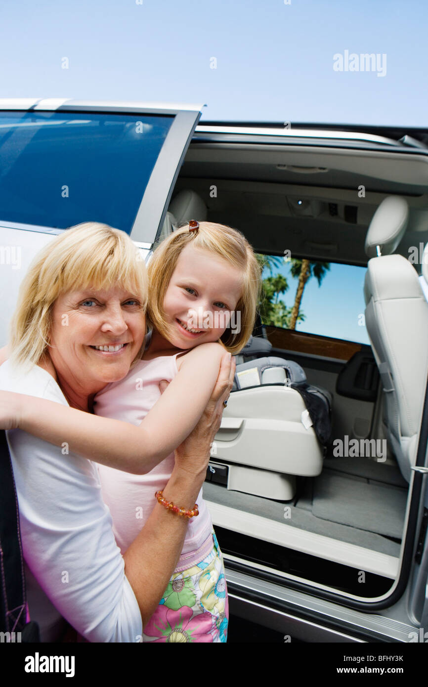 Mother Hugging Daughter by Minivan Stock Photo - Alamy