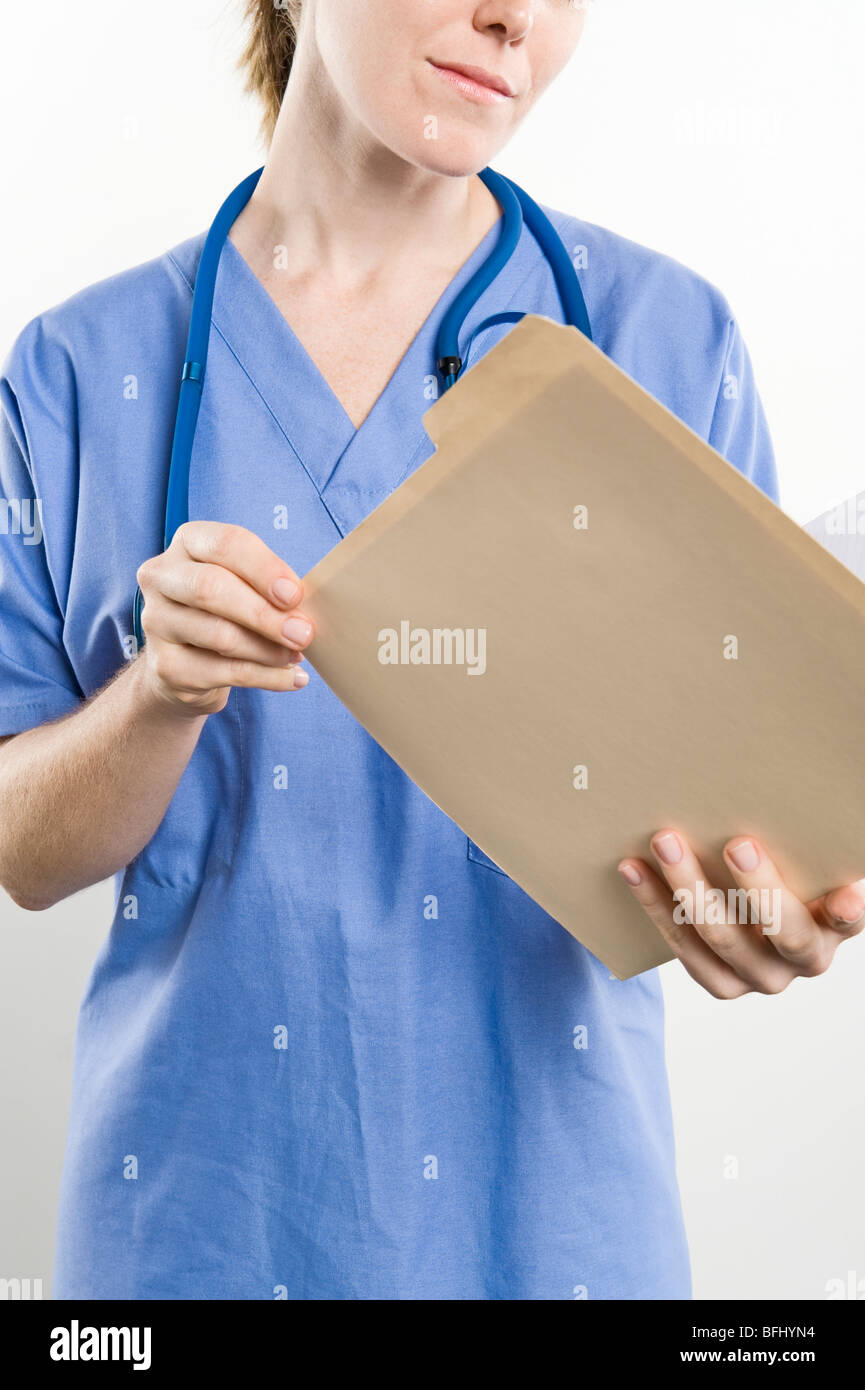 Surgeon with medical file, mid section Stock Photo - Alamy