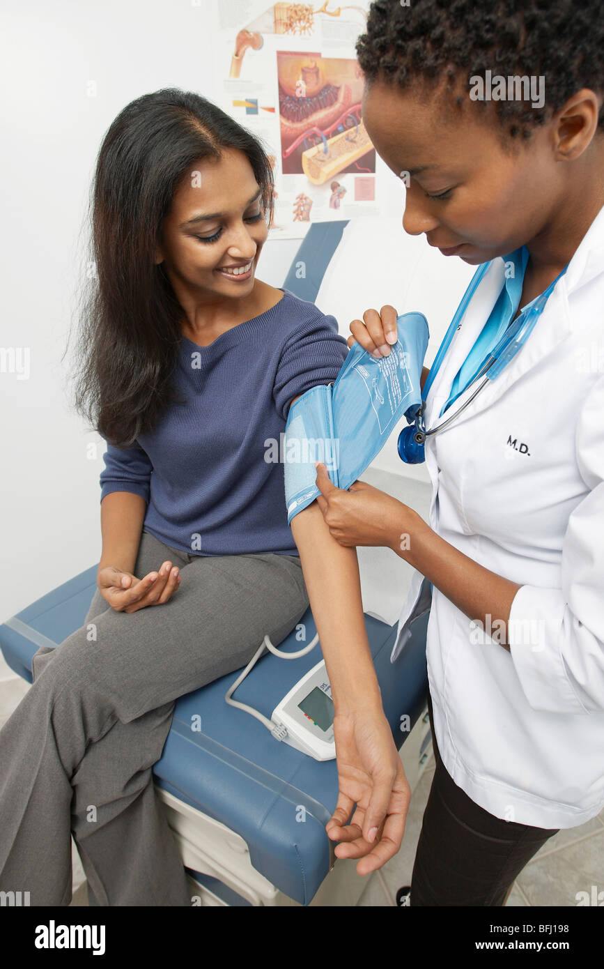 Female doctor checking patient's blood pressure Stock Photo - Alamy