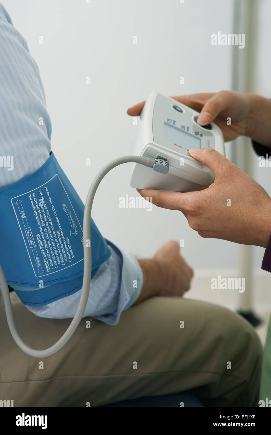 Doctor checking patients blood pressure,close-up Stock Photo - Alamy
