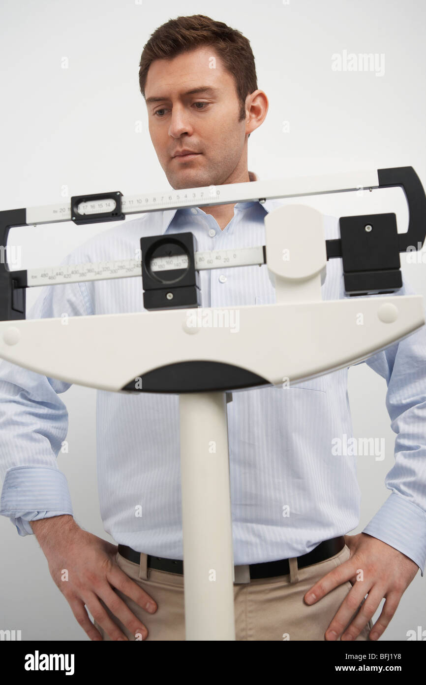 Man standing on weighing scales in hospital Stock Photo - Alamy