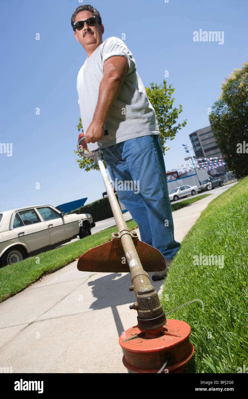 Portrait of man cutting grass Stock Photo - Alamy