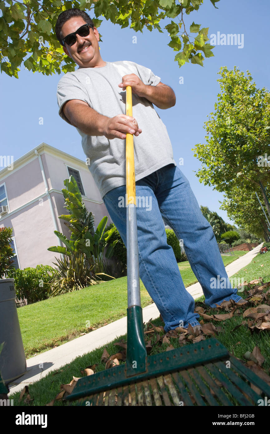 Man outdoors raking leaves smiling hi-res stock photography and images ...
