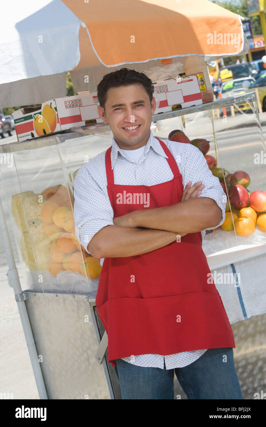 Portrait of male street vendor by stall Stock Photo - Alamy