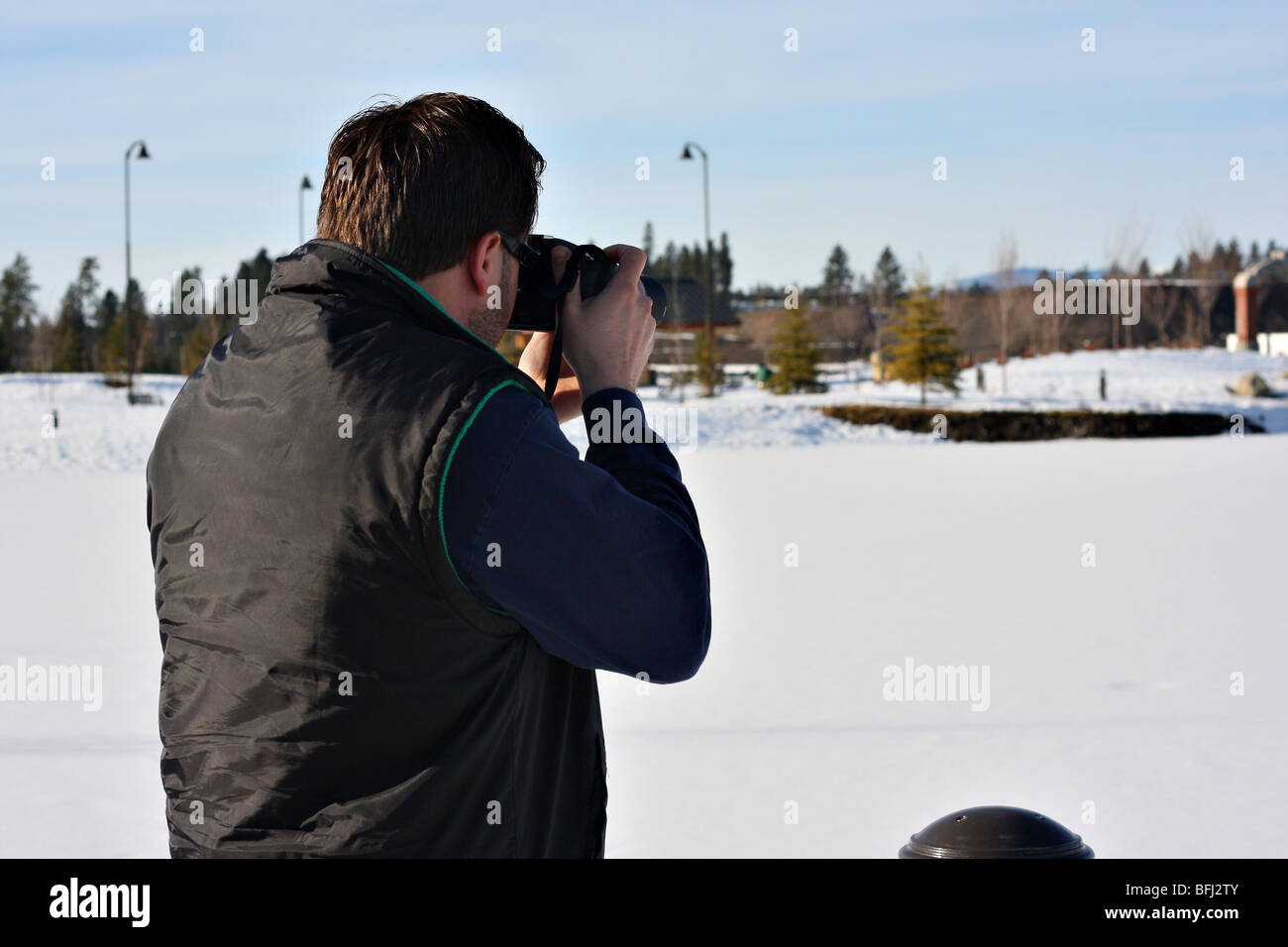 Photographer snapping pictures of a snowy and sunny landscape Stock ...