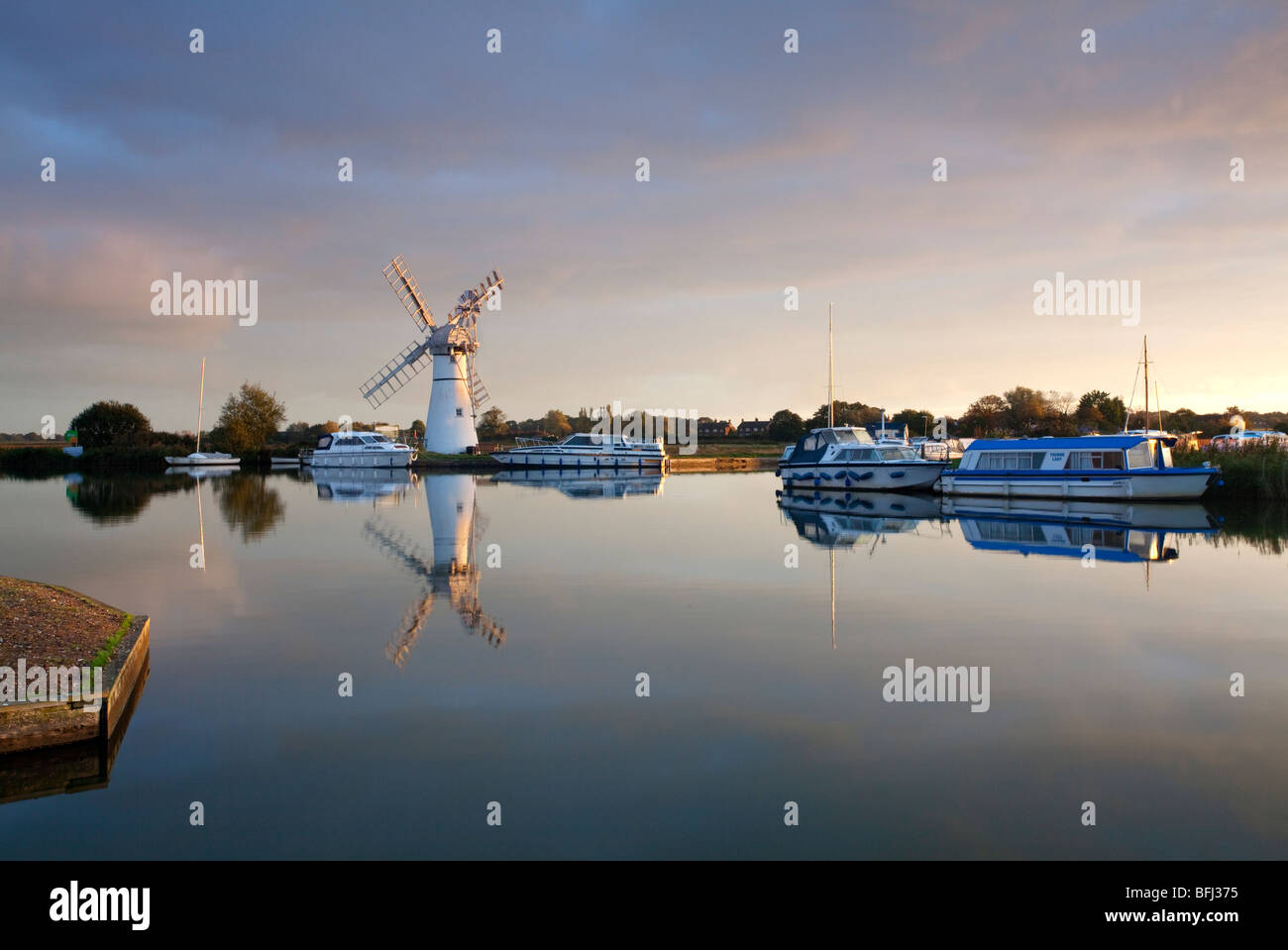 The tranquil scene of Thurne Drainage Mill at dawn reflecting in the ...