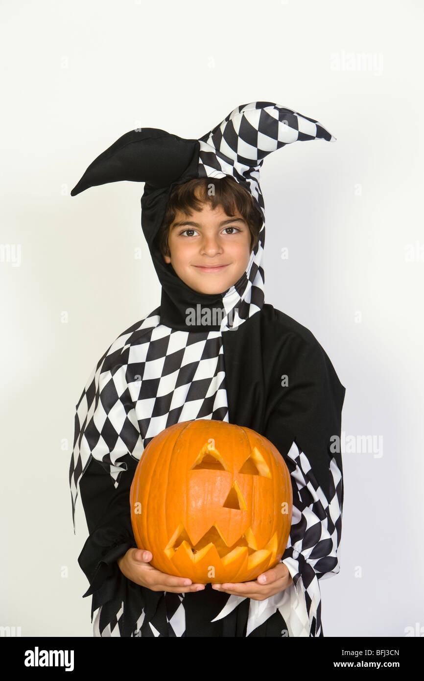 Portrait of boy (7-9) wearing jester costume, with jack-o-lantern Stock ...