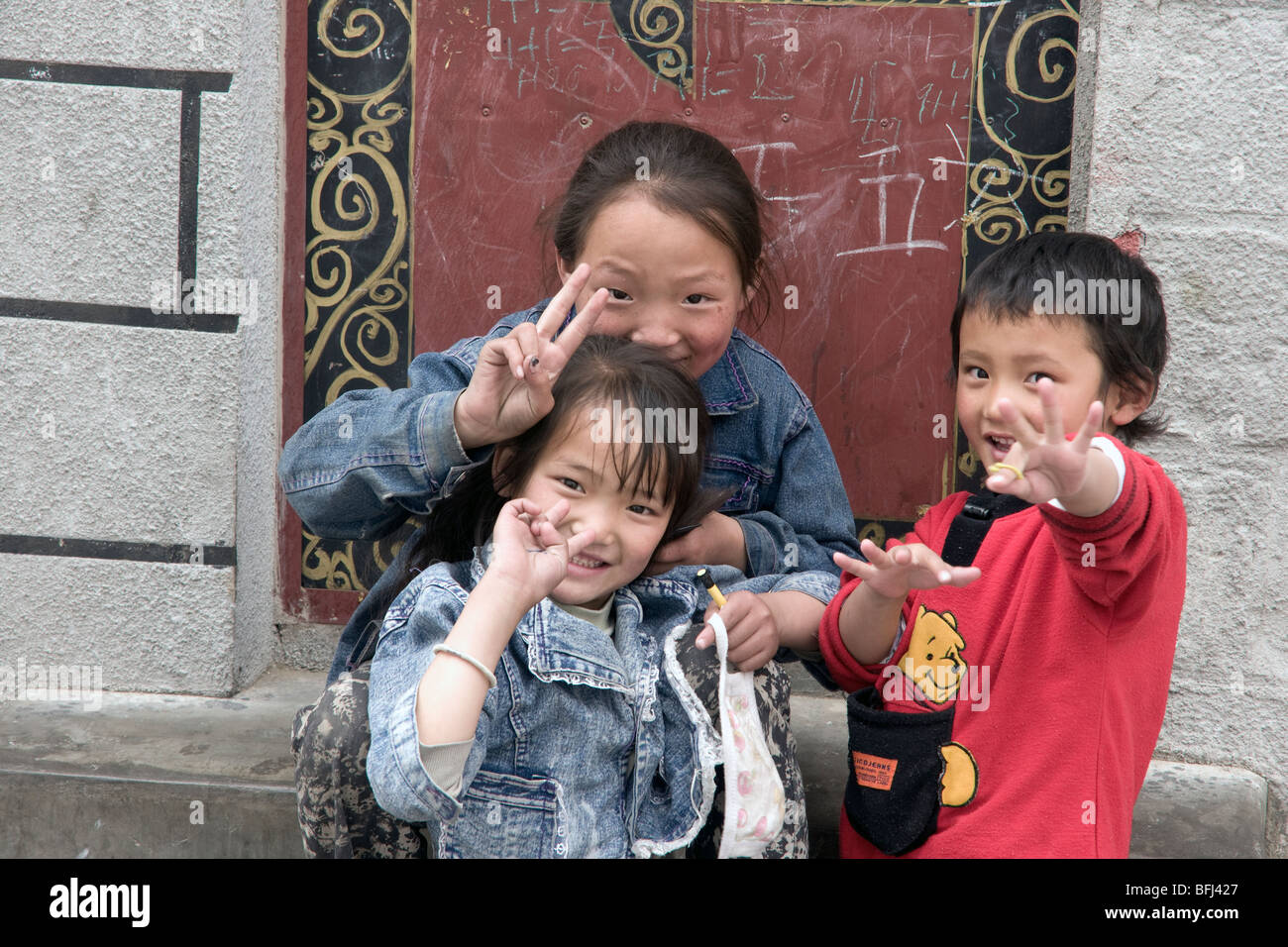 three chinese tibetan children in the back streets of the old town of ...