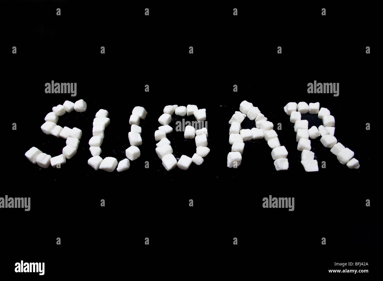 Sugar written in sugar lumps on a black studio background Stock Photo ...