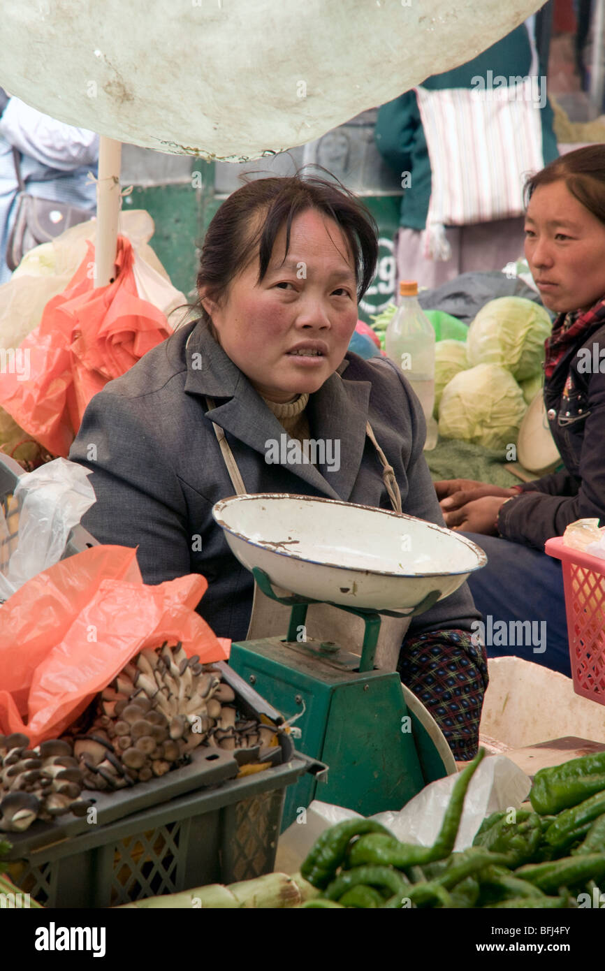 chinese woman shopkeeper at a vegetable stall in the market in lhasa ...
