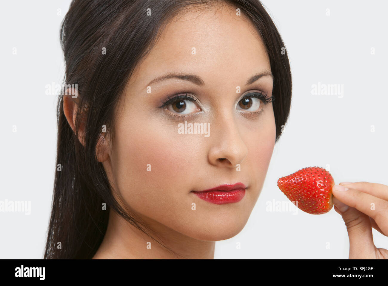 Woman eating strawberry Stock Photo - Alamy
