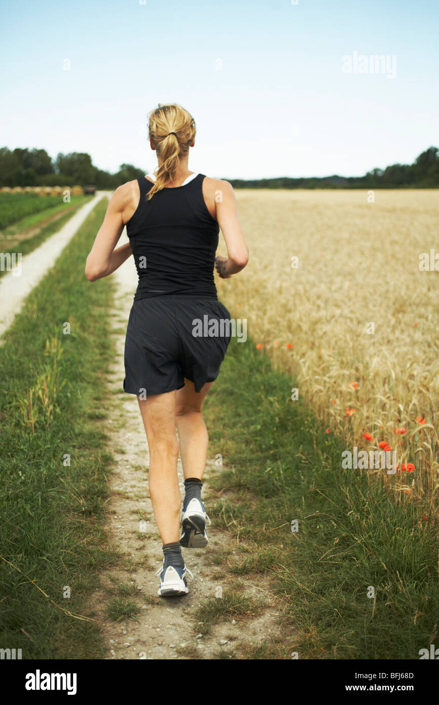 Woman jogging in an open landscape, Sweden Stock Photo - Alamy