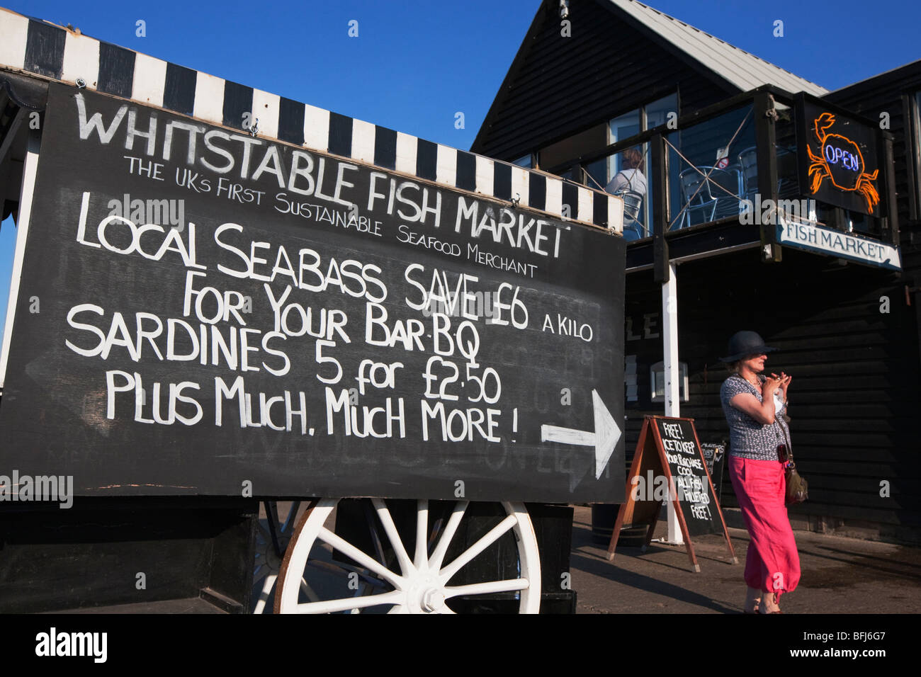 Woman in pink trousers at the fish market Whitstable Kent England Stock ...