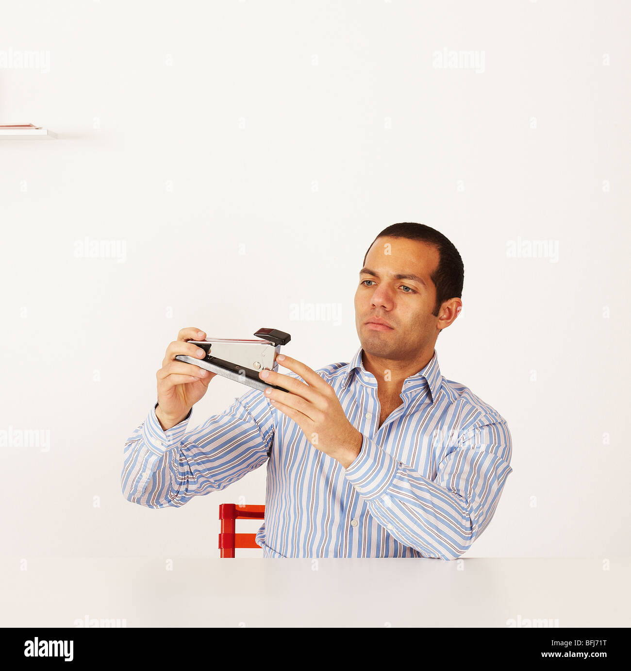 Man examining a stapler, Sweden Stock Photo - Alamy