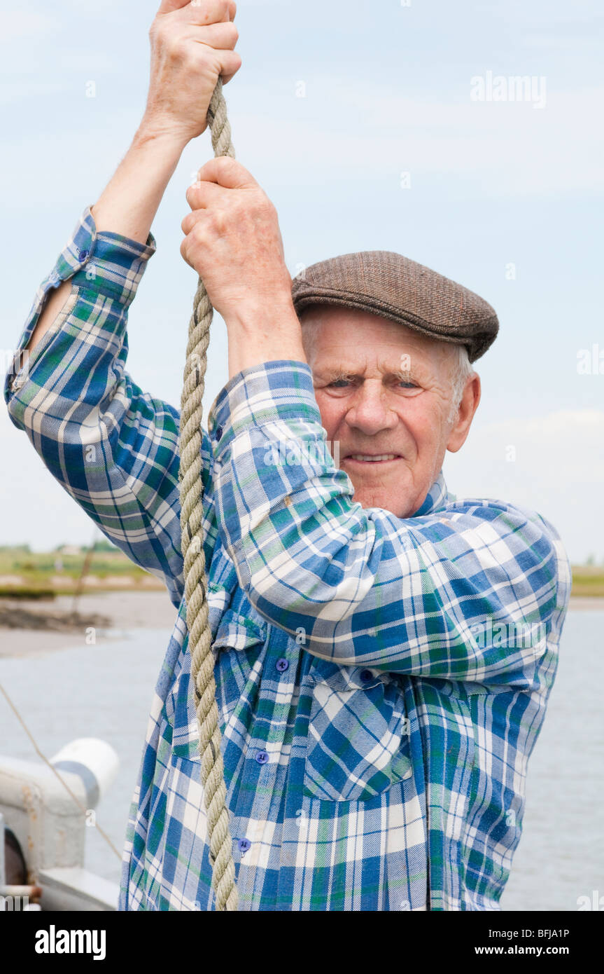 Elderly fisherman hauling rope Stock Photo - Alamy