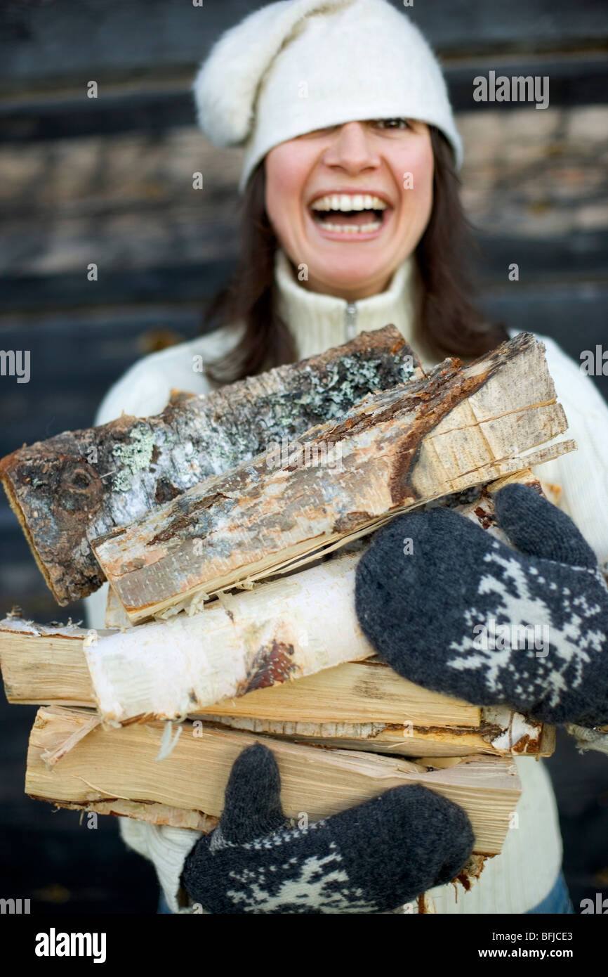 A woman carrying firewood, Dalarna, Sweden Stock Photo - Alamy