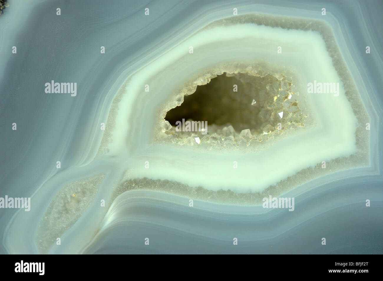Close up of a sliced geode stone with blue and white crystals showing ...