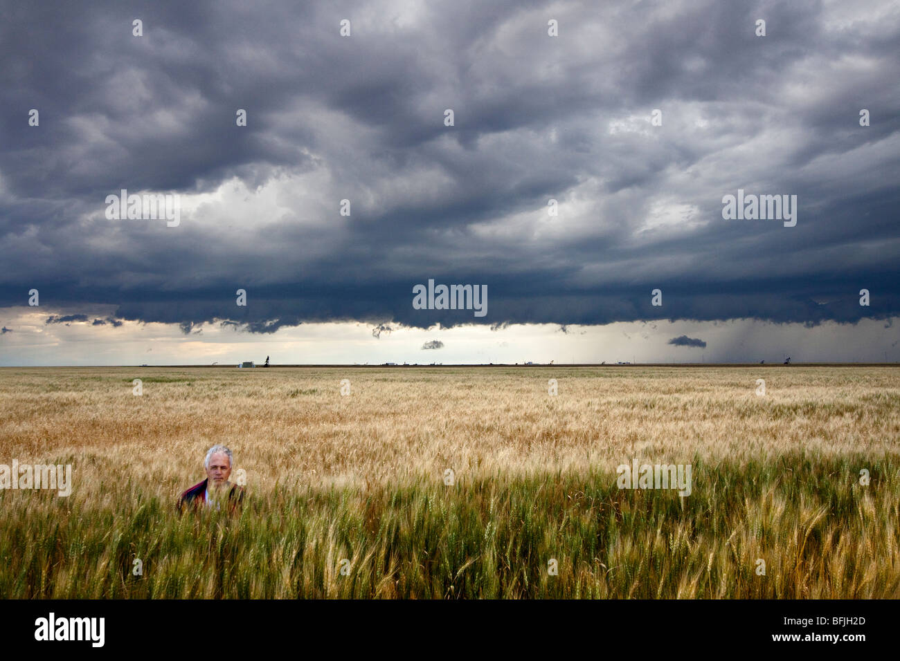 Storm chaser Tim Marshall in a prairie field in western Kansas, USA ...